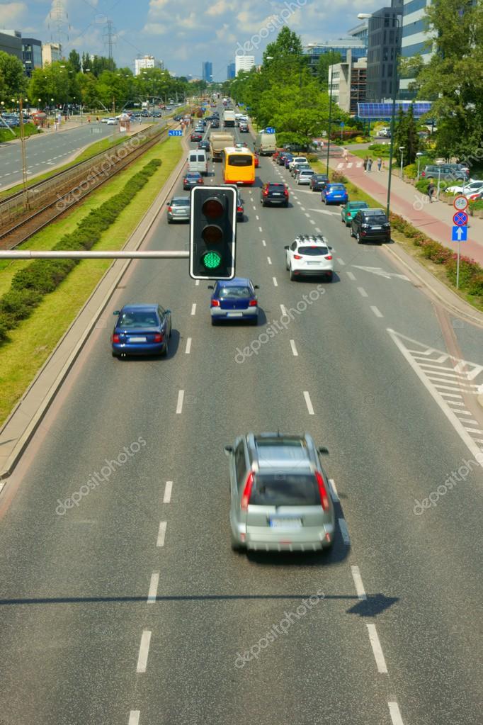 Traffic lights luminous in green and cars coming to a junction with ...