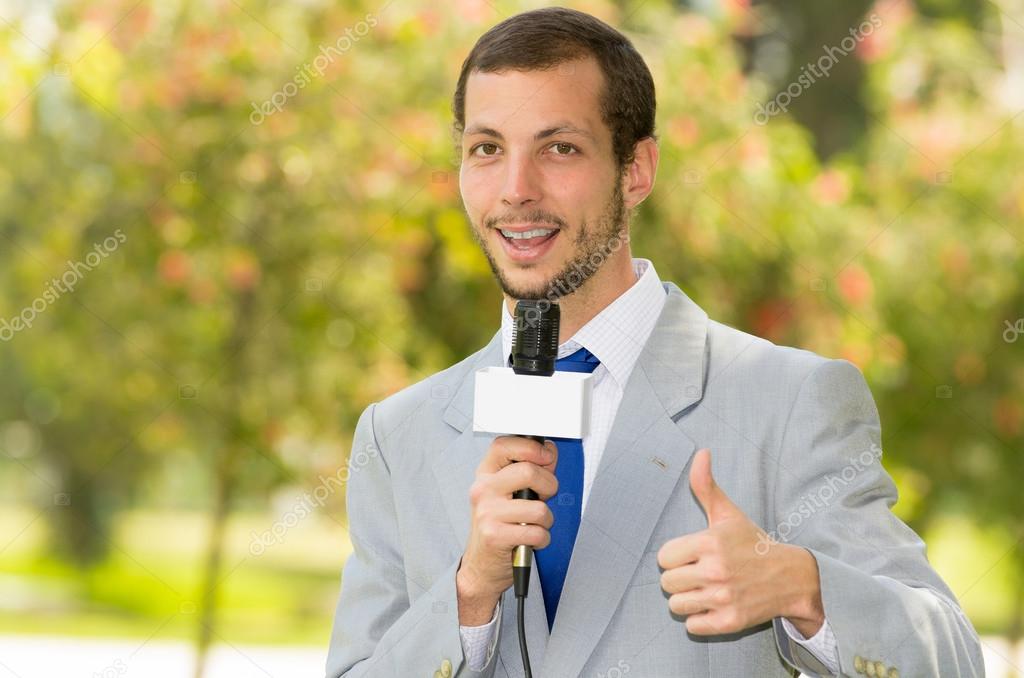 Exitoso reportero de noticias masculino guapo que usa traje gris claro ...