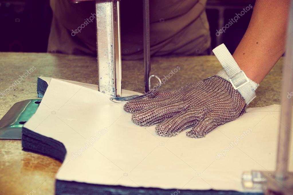 Hands wearing protection gloves using industrial machine for cutting ...