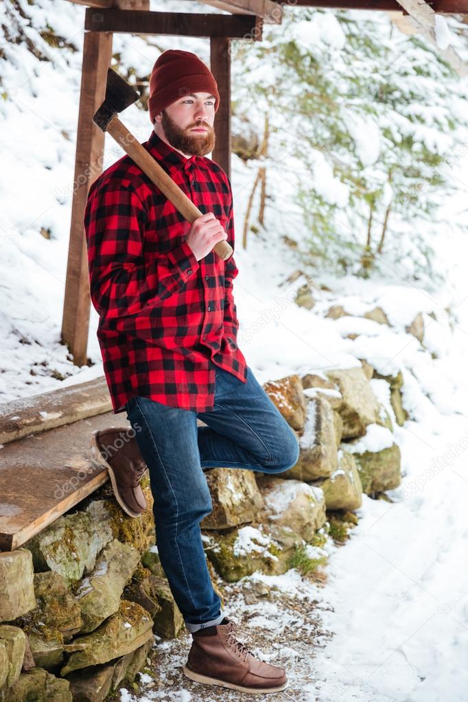Man standing with axe outdoors Stock Photo by ©Vadymvdrobot 104430236