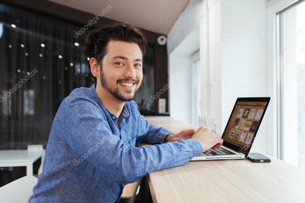 Smiling casual businessman using laptop computer — Stock Photo ... Smiling casual businessman using laptop computer — Stock Photo ...