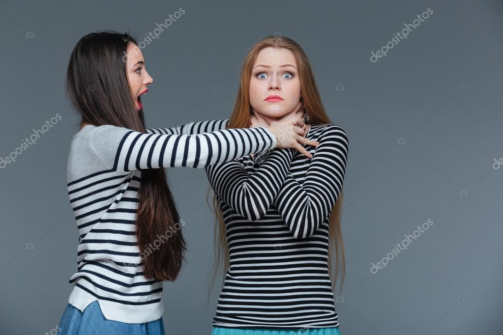 Mad angry woman standing and strangling shocked young female — Stock ...