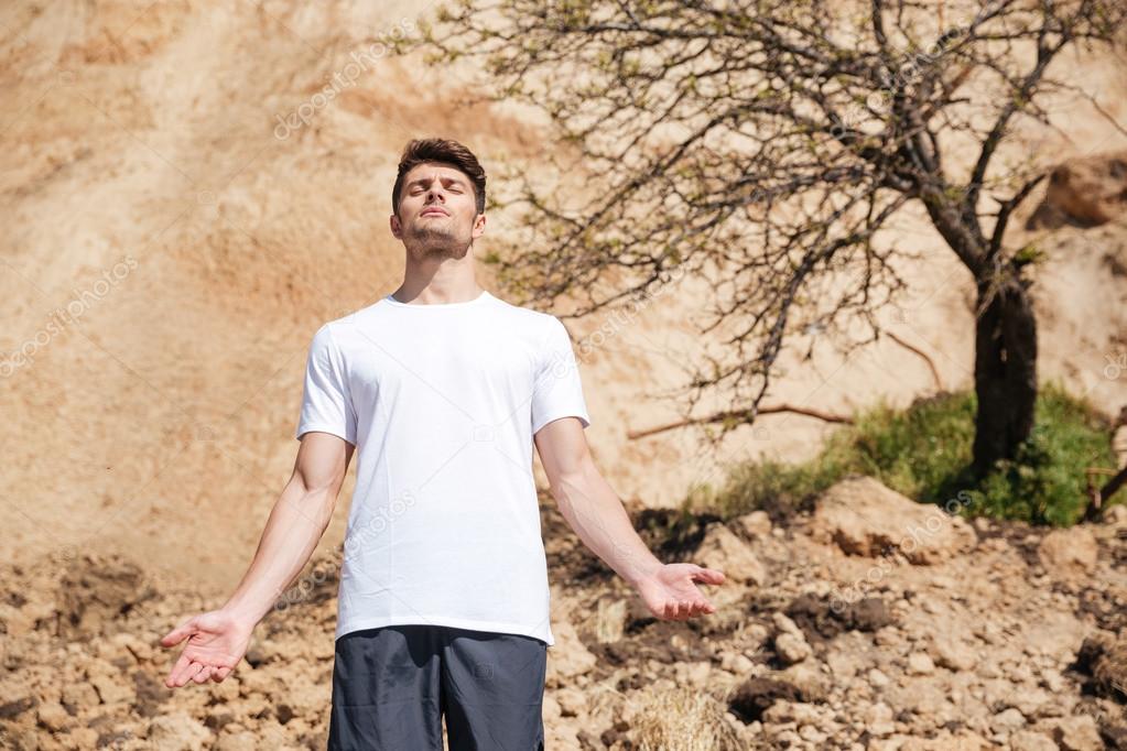 Relaxed man standing and meditating outdoors Stock Photo by ...