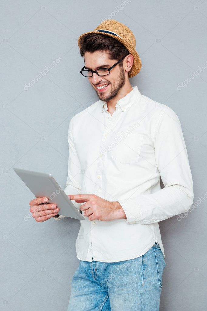 Retrato de un hombre feliz con anteojos usando tableta 2022