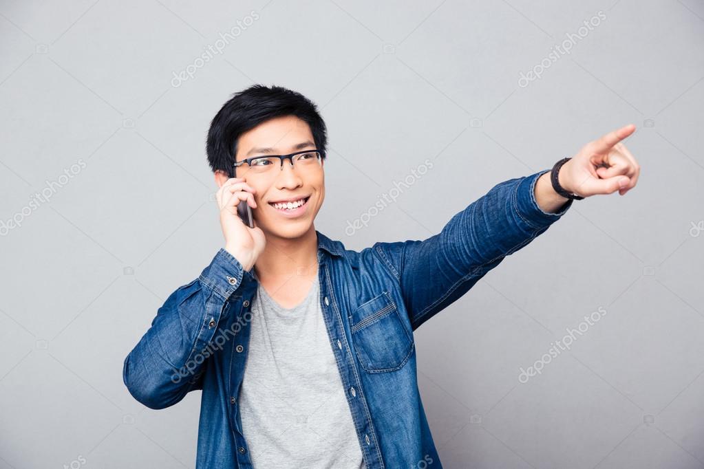 Happy asian man talking on the phone Stock Photo by ©Vadymvdrobot 71403823