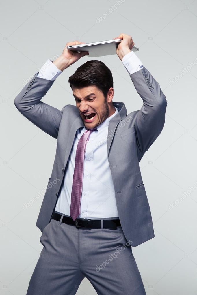Angry businessman smashing his laptop — Stock Photo © Vadymvdrobot ...