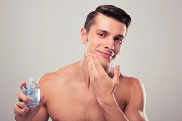Man applying lotion after shave on face - Stock Image - Everypixel