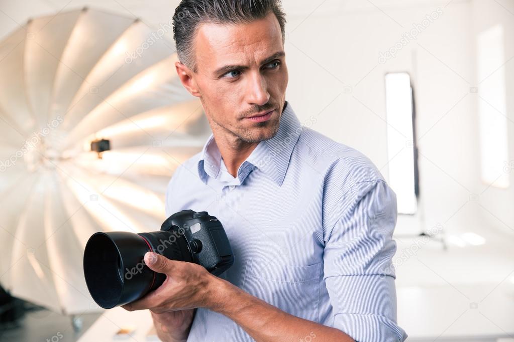 Photographer holding camera and looking away ⬇ Stock Photo, Image by ...