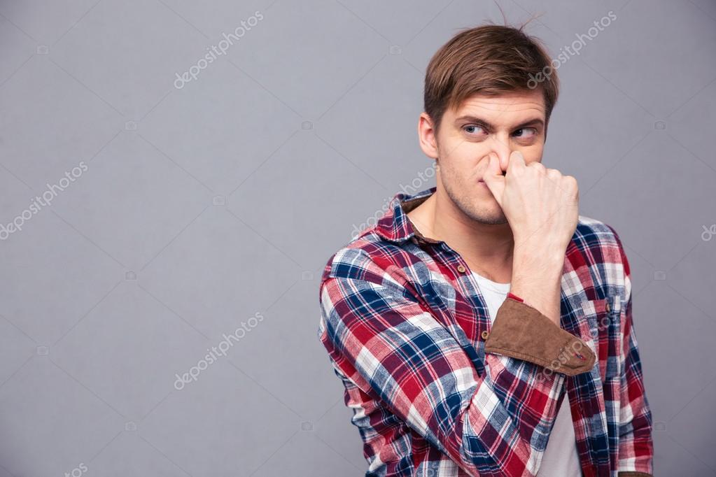 Irritated handsome young man in plaid shirt covered his nose — Stock ...