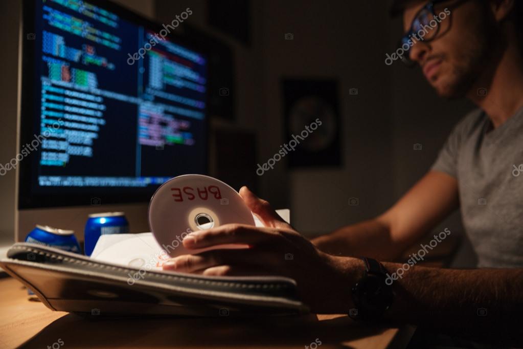 Programador seguro tomando cd con base de datos y codificación 2024