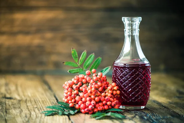 Rowanberry tincture vodka on wooden table - Stock Image - Everypixel