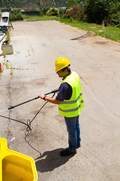 Worker in hard hat pressure washing - Stock Image - Everypixel