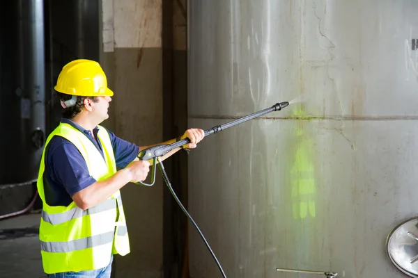 Worker in hard hat pressure washing - Stock Image - Everypixel