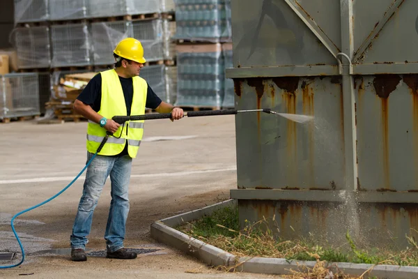 Worker in hard hat pressure washing - Stock Image - Everypixel