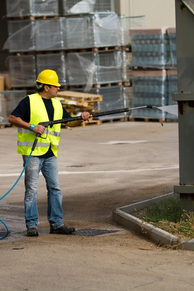 Worker in hard hat pressure washing - Stock Image - Everypixel