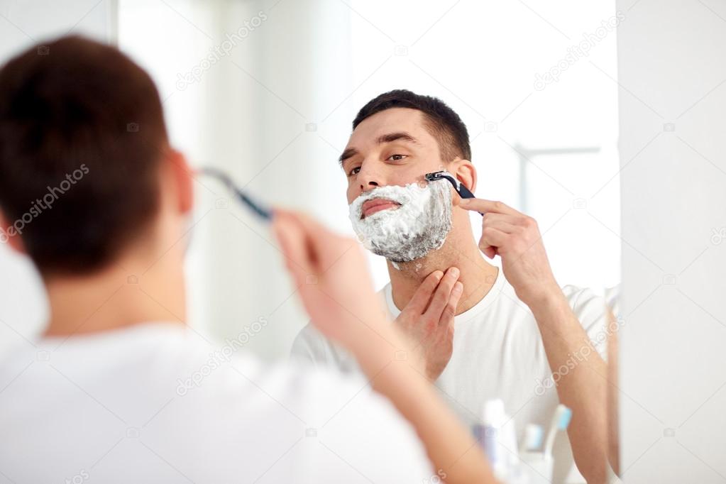 Man shaving beard with razor blade at bathroom — Stock Photo © Syda ...