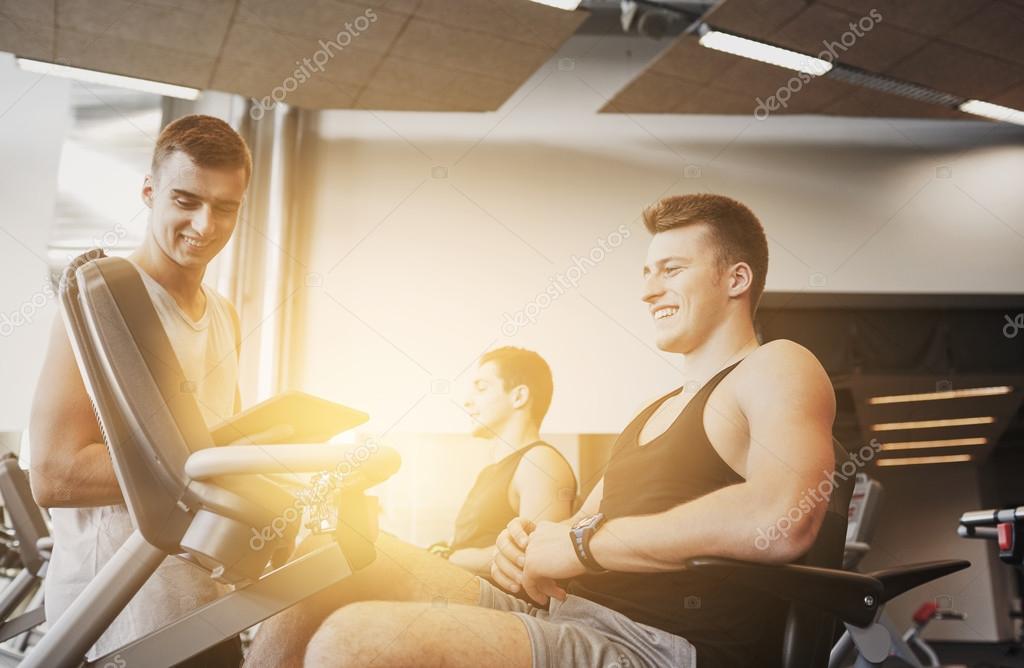 Men exercising on gym machine Stock Photo by ©Syda_Productions 116977792