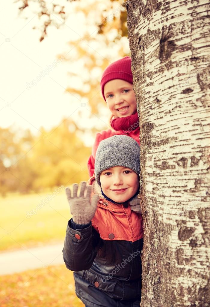 Happy children hiding behind tree and waving hand — Stock Photo © Syda ...