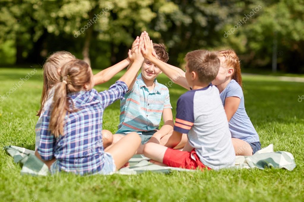 Group of happy kids making high five outdoors — Stock Photo © Syda ...