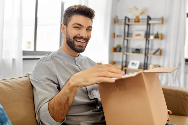 happy smiling man opening parcel box at home - Stock Image - Everypixel