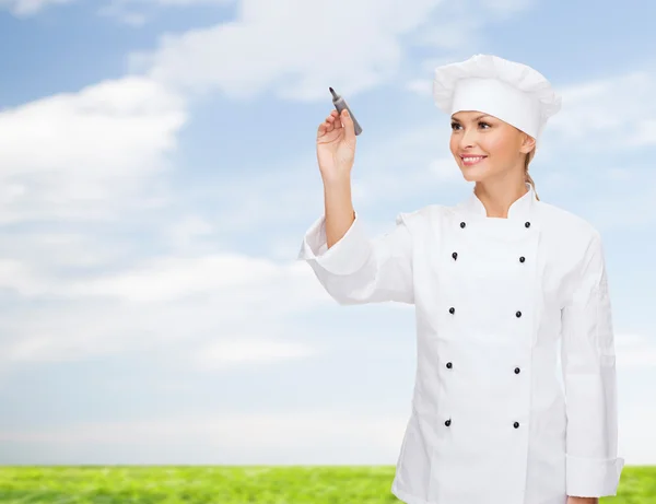 Smiling female chef writing something on air Stock Photo by ©Syda ...