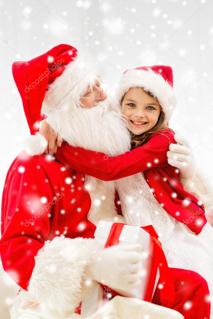 Smiling girl hugging santa claus with gift at home — Stock Photo © Syda ...
