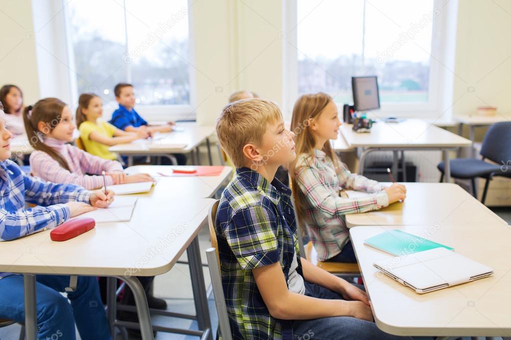 Group of school kids with notebooks in classroom Stock Photo by ©Syda ...