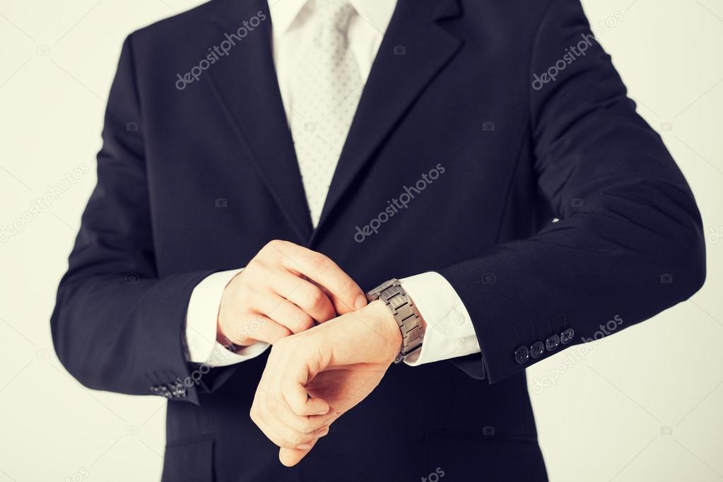 Man looking at wristwatch Stock Photo by ©Syda_Productions 64751347