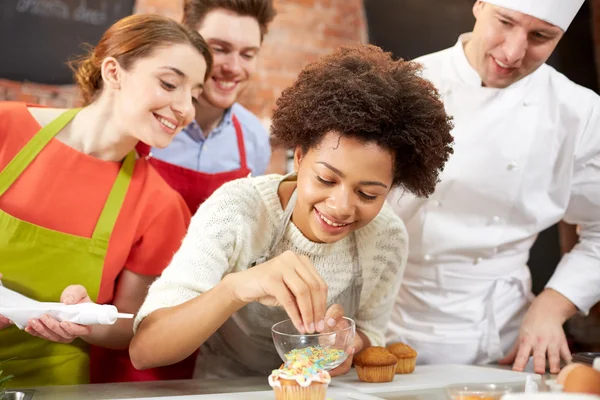Happy friends and chef cook baking in kitchen - Stock Image - Everypixel