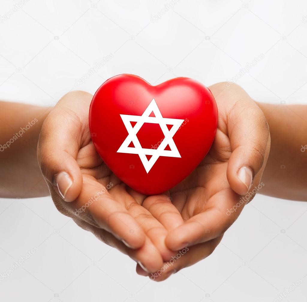 manos femeninas sosteniendo el corazón con la estrella de David 2023