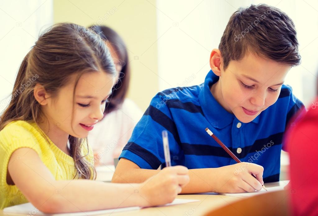 Group of school kids writing test in classroom Stock Photo by ©Syda ...