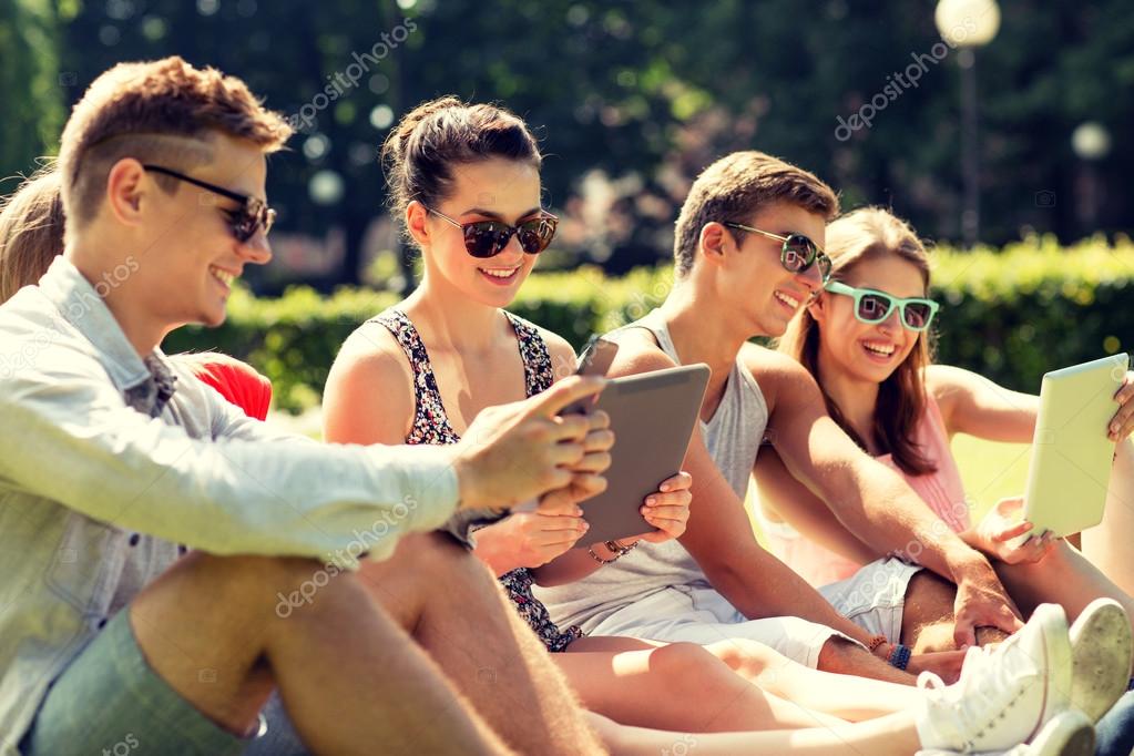 Smiling friends with tablet pc computers in park — Stock Photo © Syda ...