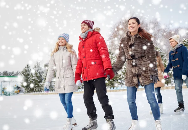 happy friends ice skating on rink outdoors - Stock Image - Everypixel