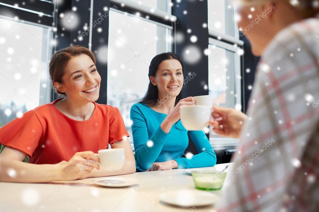 mujeres jóvenes felices tomando té o café en la cafetería 2023