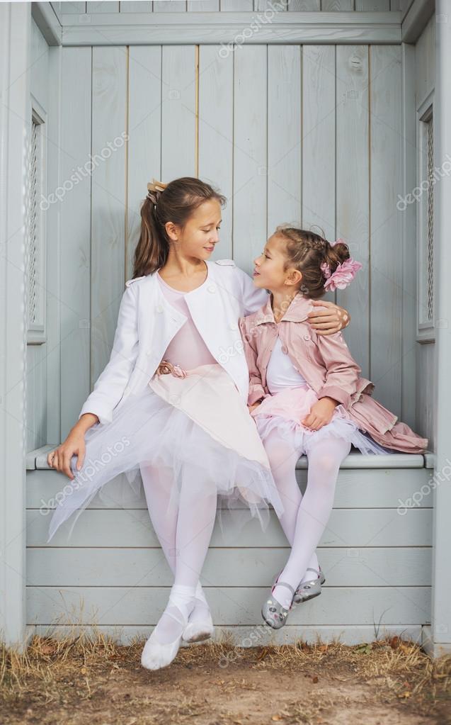 Two adorable sisters higging in the arbour — Stock Photo © konradbak ...