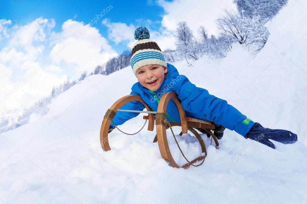 Little boy on sledge slide Stock Photo by ©serrnovik 117650014