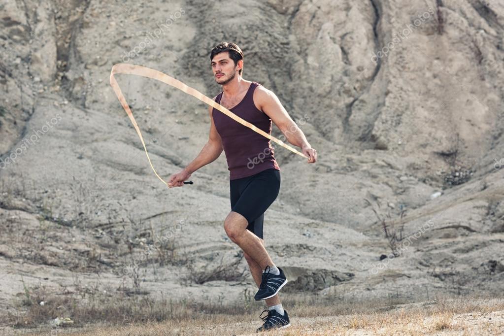 Sporty man jumping rope outdoors Stock Photo by ©chesterf 59484173