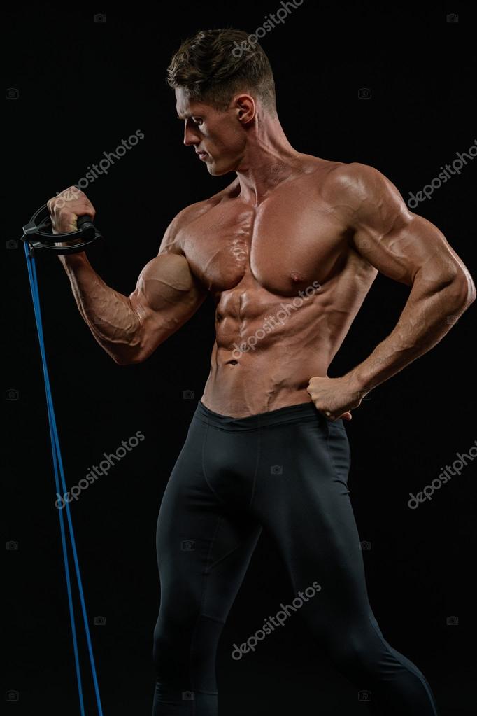 atleta masculino musculoso guapo realiza ejercicios con expansores 2023