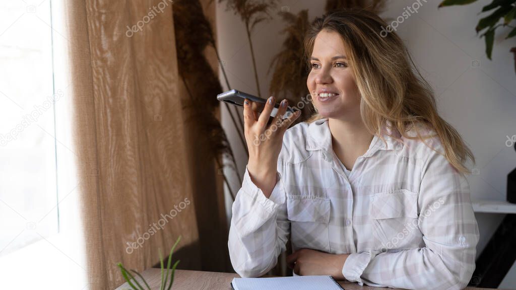 joven chica caucásica activando asistente virtual en un teléfono móvil ...
