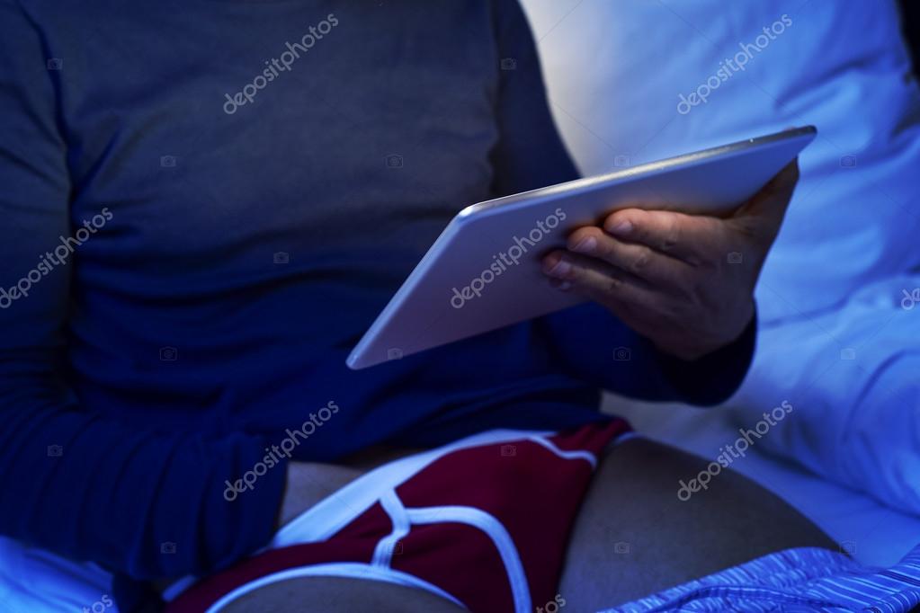 Man grabbing his crotch while watches his tablet — Stock Photo ...