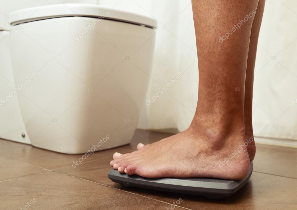 Young man standing on a scale Stock Photo by ©nito103 123213658