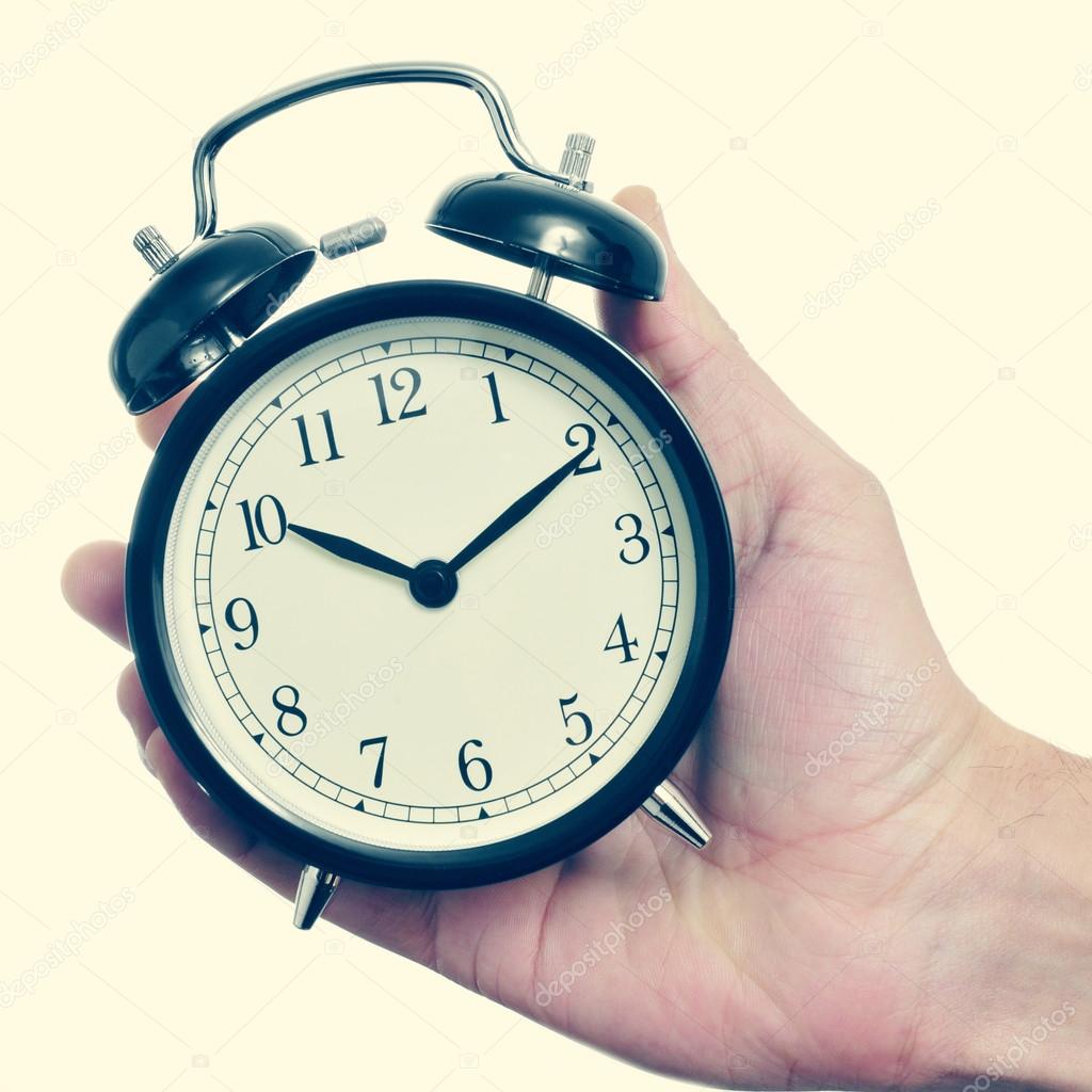 Man hand holding a mechanical alarm clock, with a retro effect Stock ...