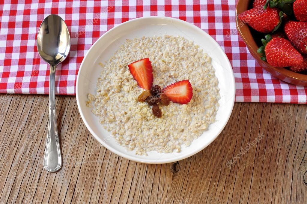 Bowl with porridge on a set table for breakfast — Stock Photo © nito103 ...