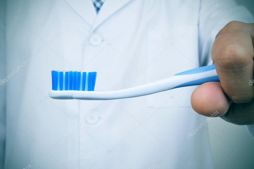 A dentist showing a toothbrush — Stock Photo © nito103 #77500028
