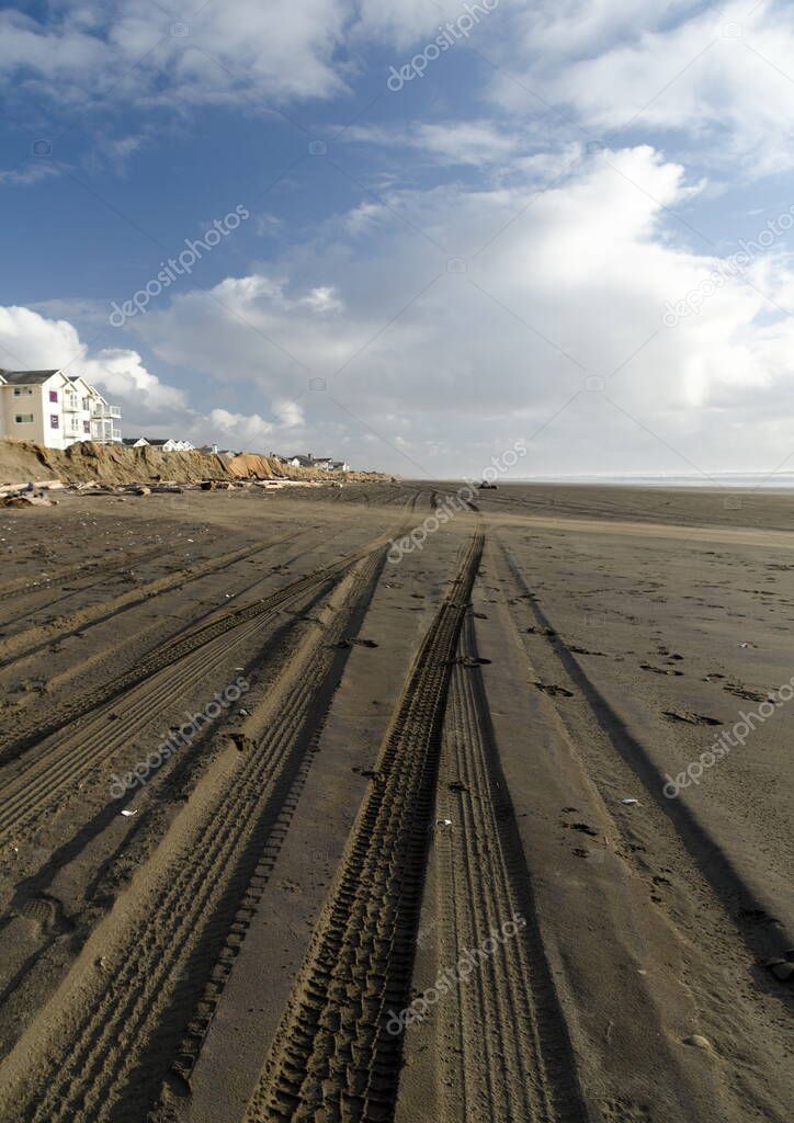Pistas de neum ticos que corren a lo largo de la playa de arena en el Parque Estatal del Faro de ...