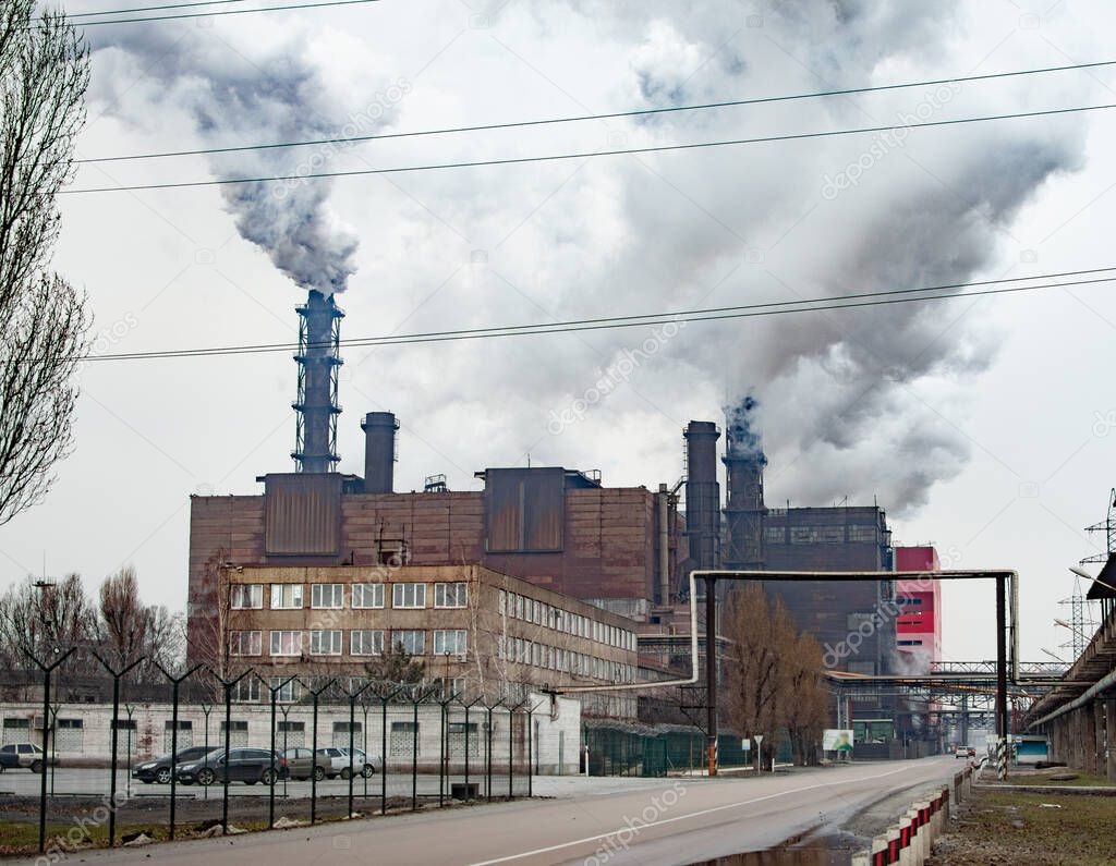 El denso humo viene de tuberías de chimenea industriales. Tuberías con humo, producción ...