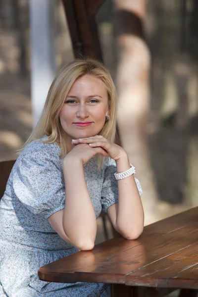 Woman sitting on table and looking straight - Stock Image - Everypixel