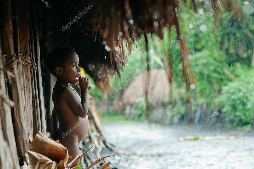 Papuan boy from Dani tribe hides from a rain under a roof. — Stock Editorial Photo © SURZet ...