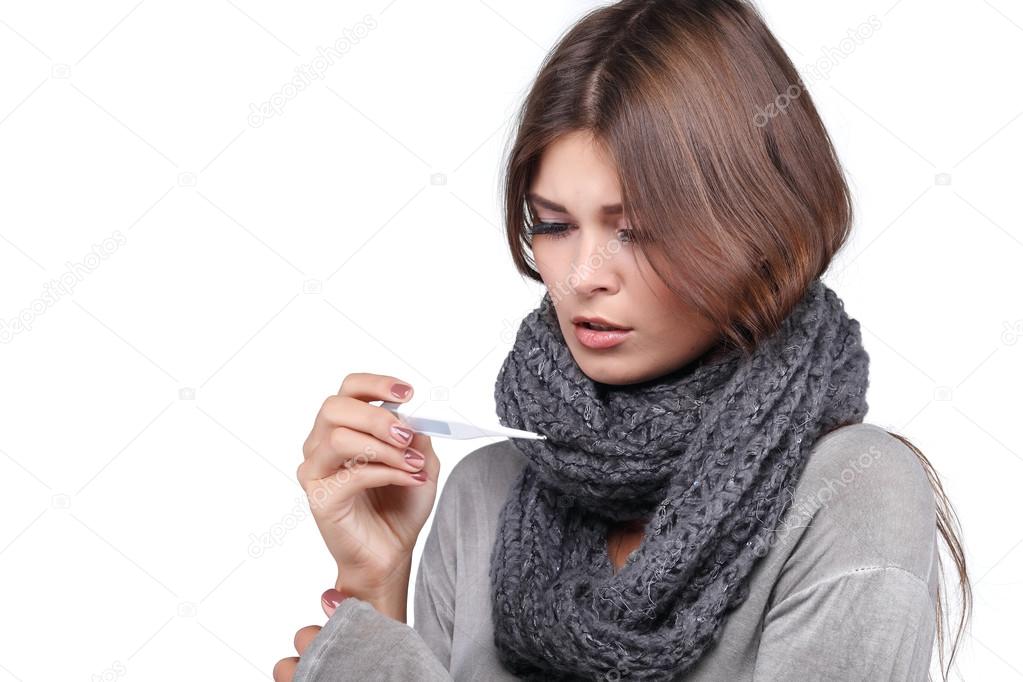 Woman taking her temperature wile feeling sick and with fever, isolated ...