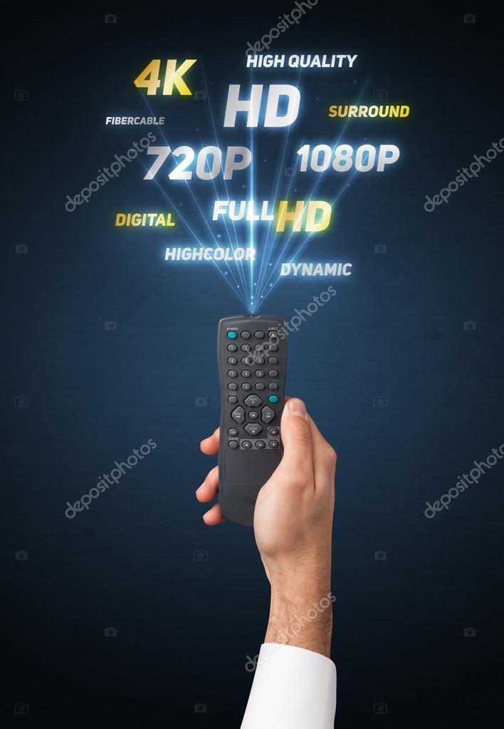 Hand with remote control and multimedia properties — Stock Photo ...